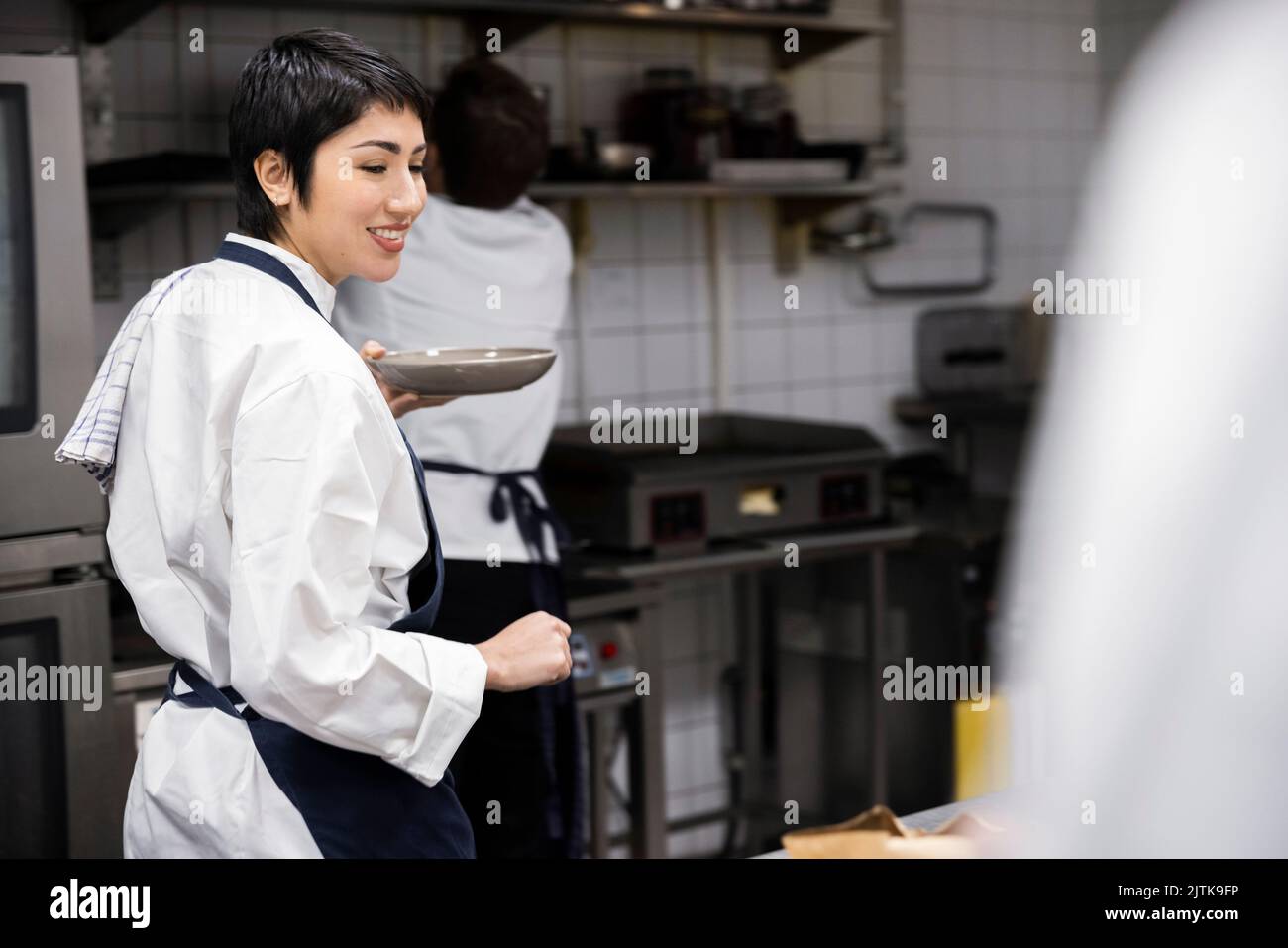 Smiling female chef plate hi-res stock photography and images - Alamy