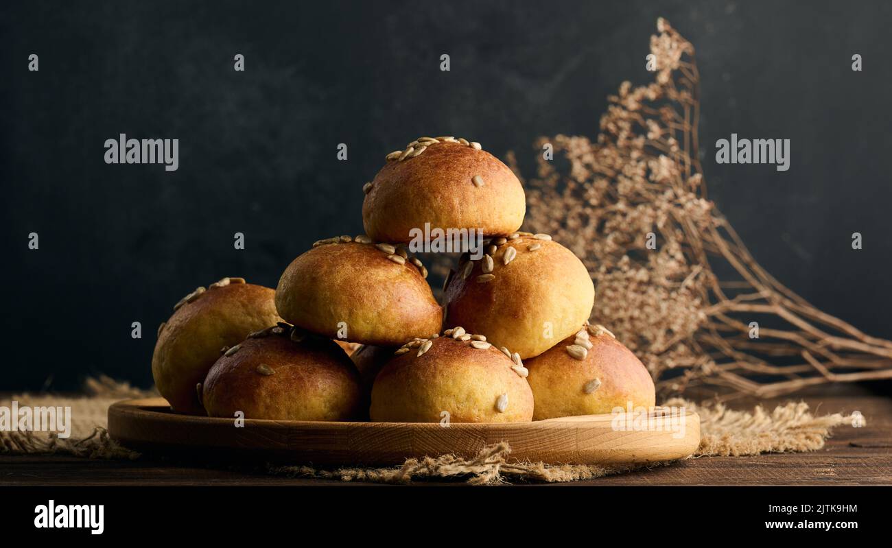 Baked round buns on a wooden table, black background Stock Photo - Alamy