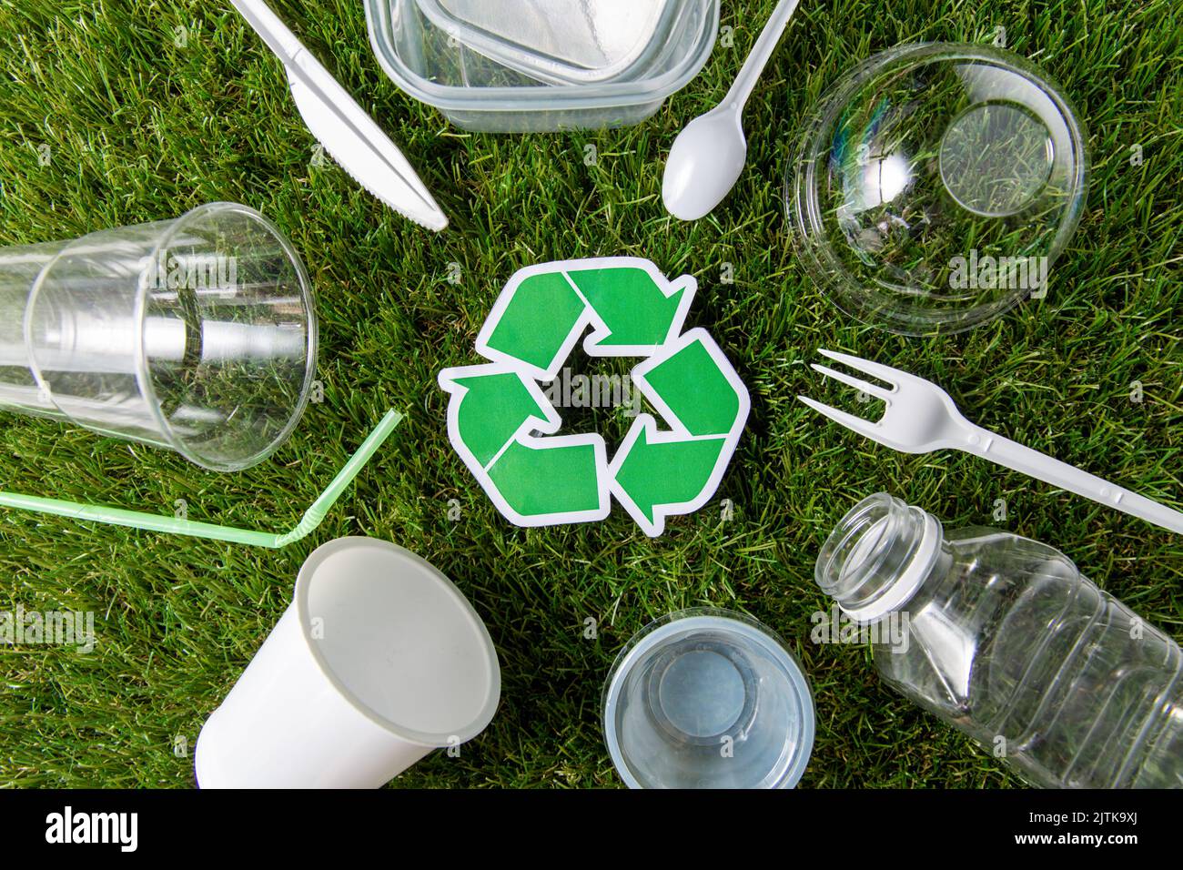 green recycling sign and plastic waste on grass Stock Photo - Alamy