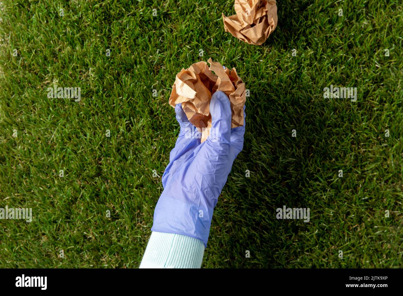 close up of hand in glove picking paper waste Stock Photo - Alamy