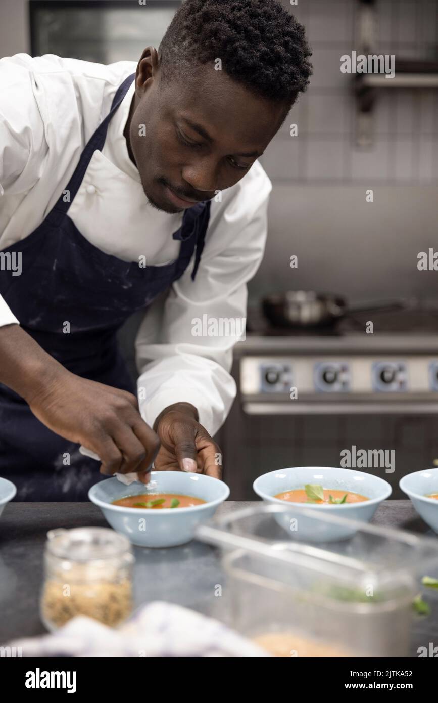 Male chef wiping bowl of soup while working at restaurant Stock Photo ...