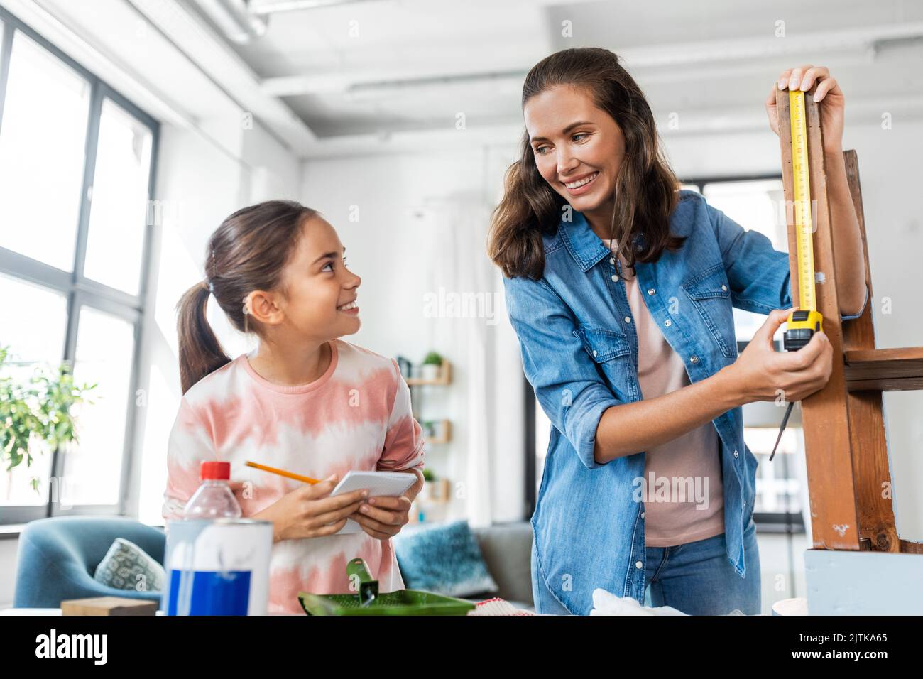 mother and daughter with ruler measuring old table Stock Photo - Alamy