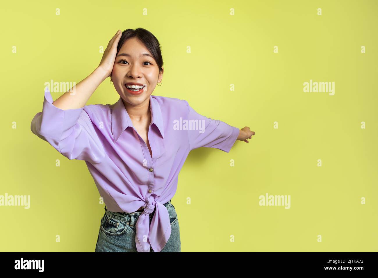 Excited Asian Female Pointing Aside Advertising Wow Offer, Yellow ...