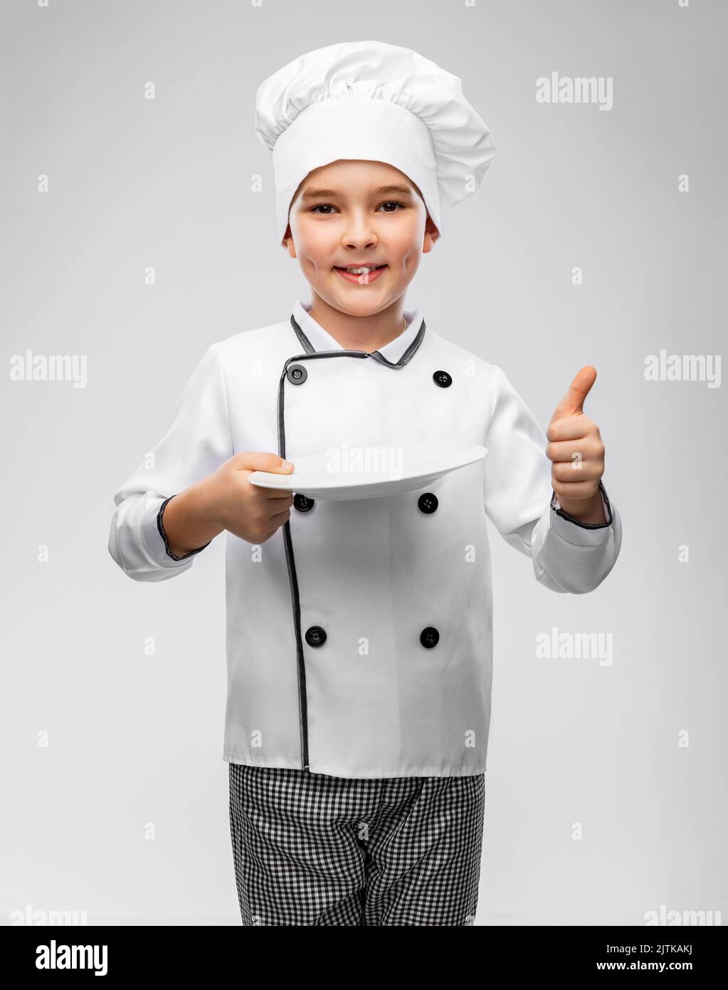 boy in chef's toque with plate showing thumbs up Stock Photo - Alamy