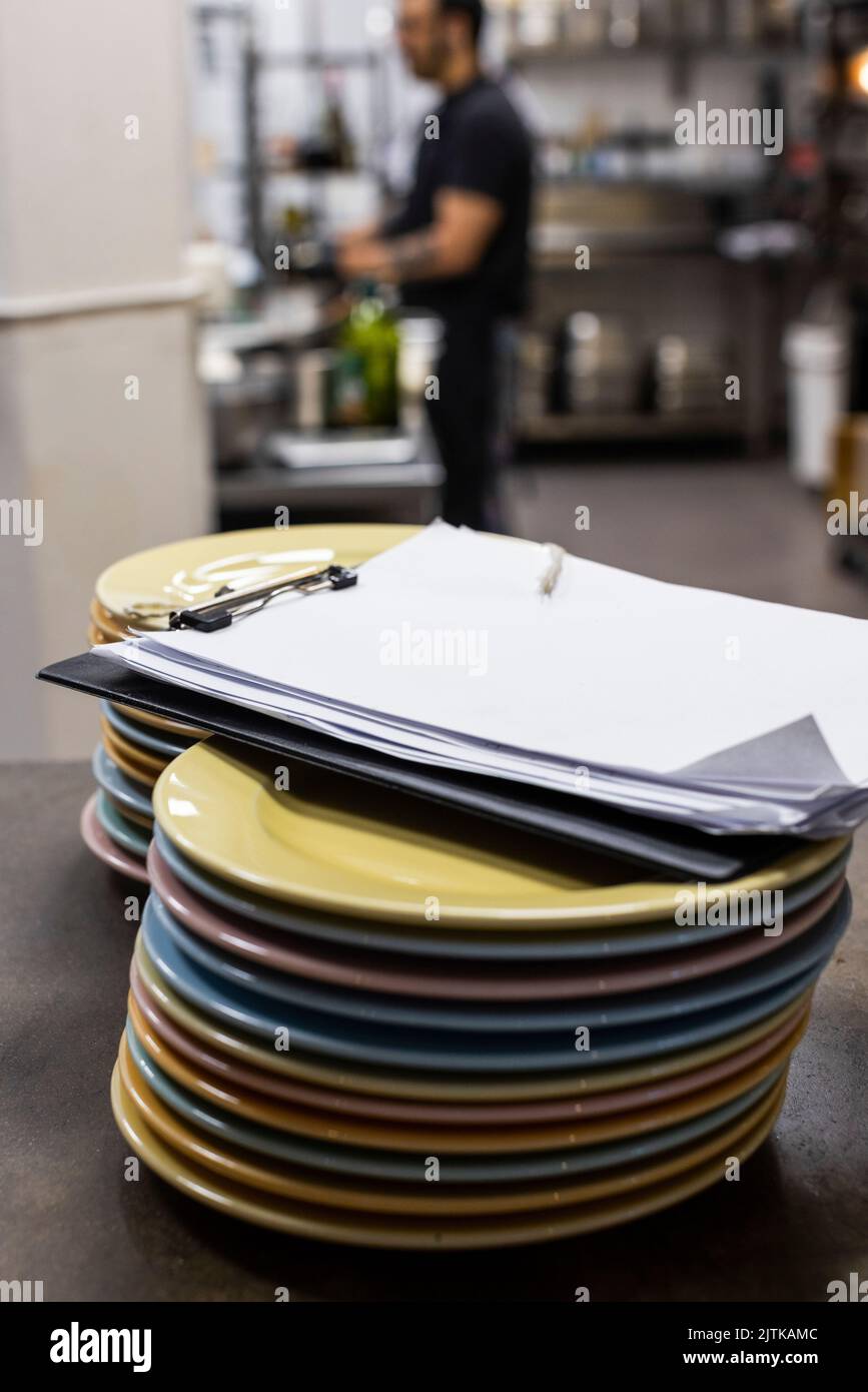 Clipboard on stack of plates on kitchen counter in restaurant Stock ...
