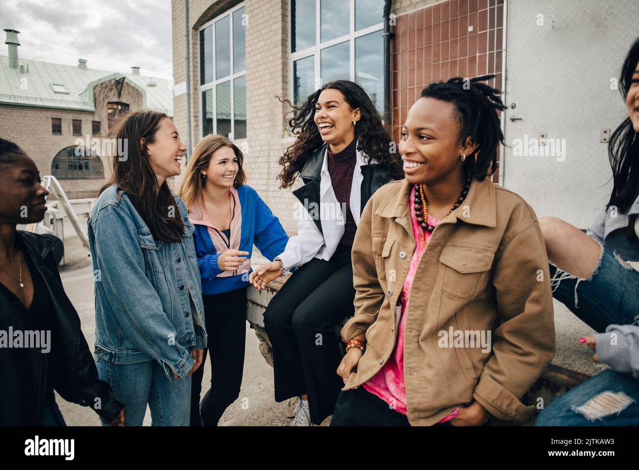 Happy multiracial young friends talking outside building Stock Photo ...