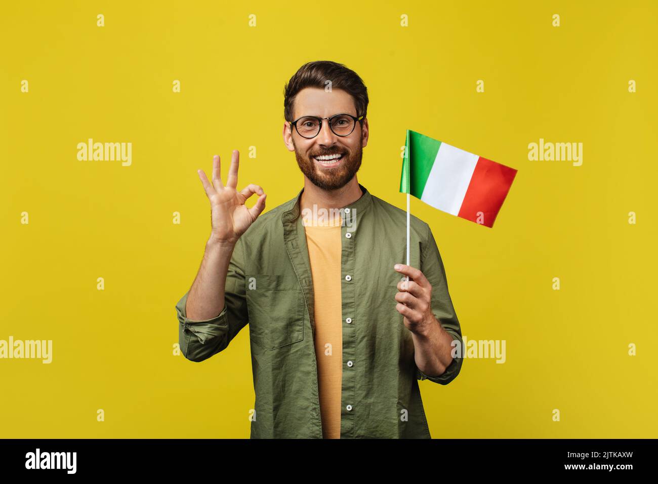 Positive man showing flag of Italy and gesturing okey, posing over ...