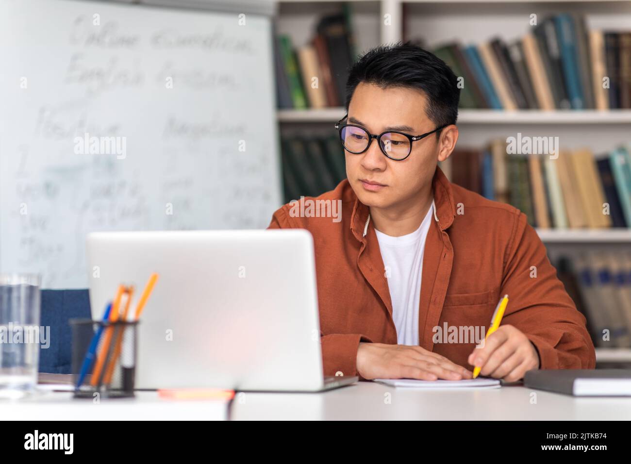 Korean Middle Aged Teacher Using Laptop Taking Notes In Classroom Stock ...