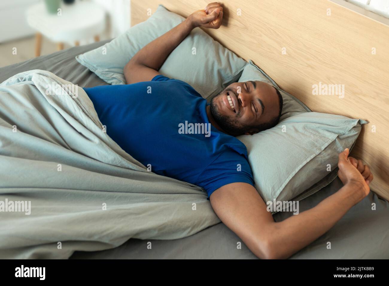 Happy Black Male Stretching After Good Sleep Lying In Bedroom Stock ...