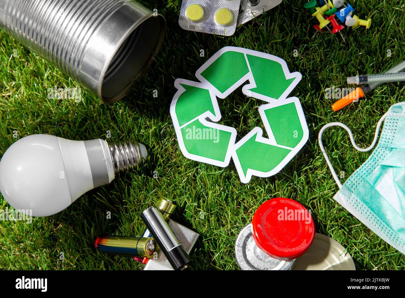 green recycle sign with household waste on grass Stock Photo - Alamy