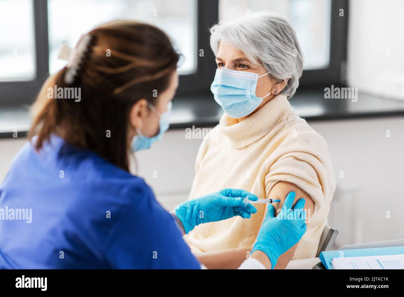 nurse with syringe making injection to woman Stock Photo - Alamy