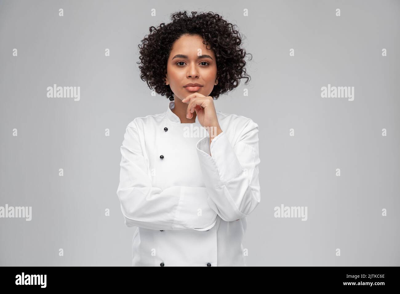 thinking female chef over grey background Stock Photo - Alamy