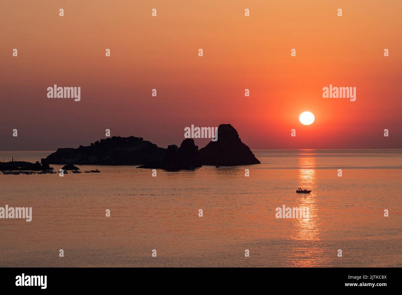 Sunrise behind the Faraglioni or Isole dei Ciclopi (Cyclopean Islands ...