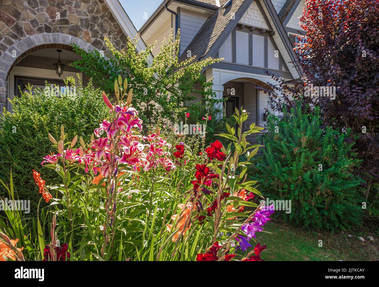 Entrance to a home through a beautiful garden with colorful flowers ...