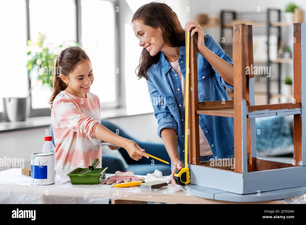 mother and daughter with ruler measuring old table Stock Photo - Alamy