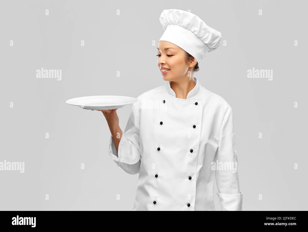 happy smiling female chef holding empty plate Stock Photo - Alamy