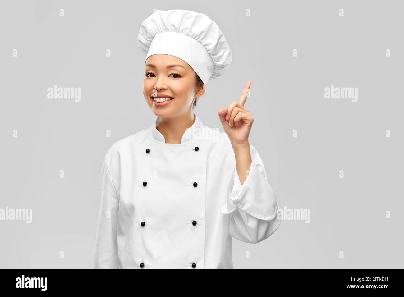 Portrait of young woman chef pointing direction Stock Photo - Alamy