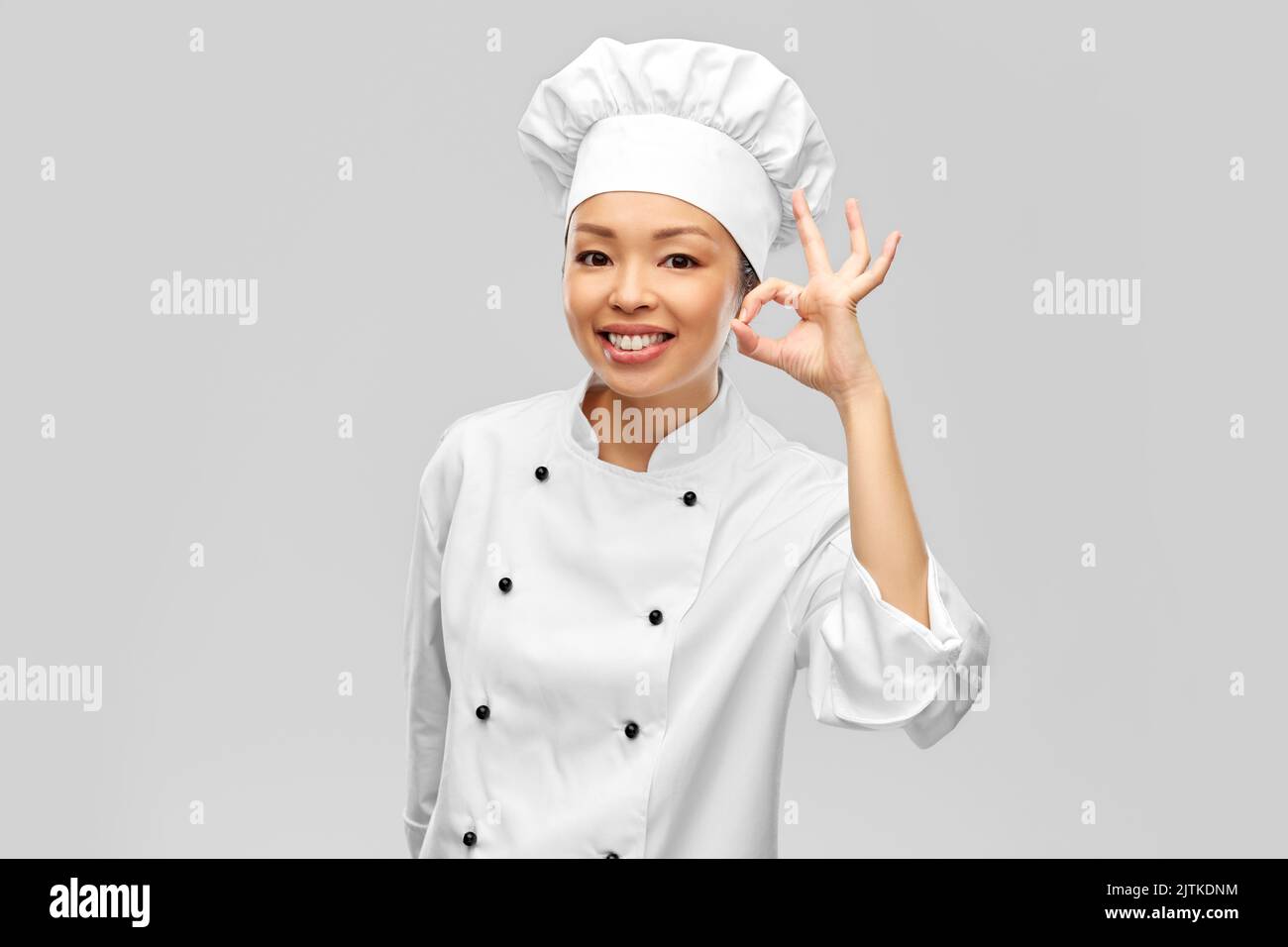 happy smiling female chef showing ok hand sign Stock Photo - Alamy
