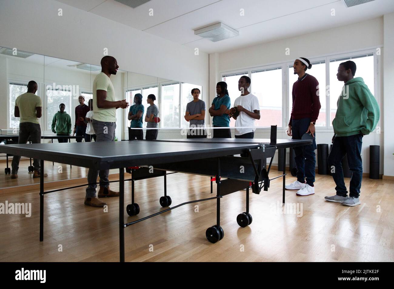 Coach listening to students during training session in games room Stock ...