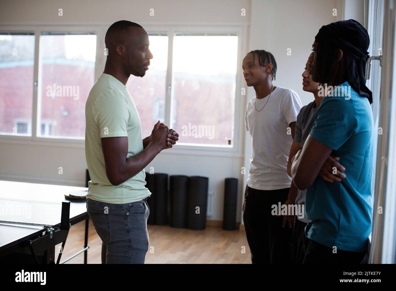 Coach giving training session to students in games room Stock Photo - Alamy