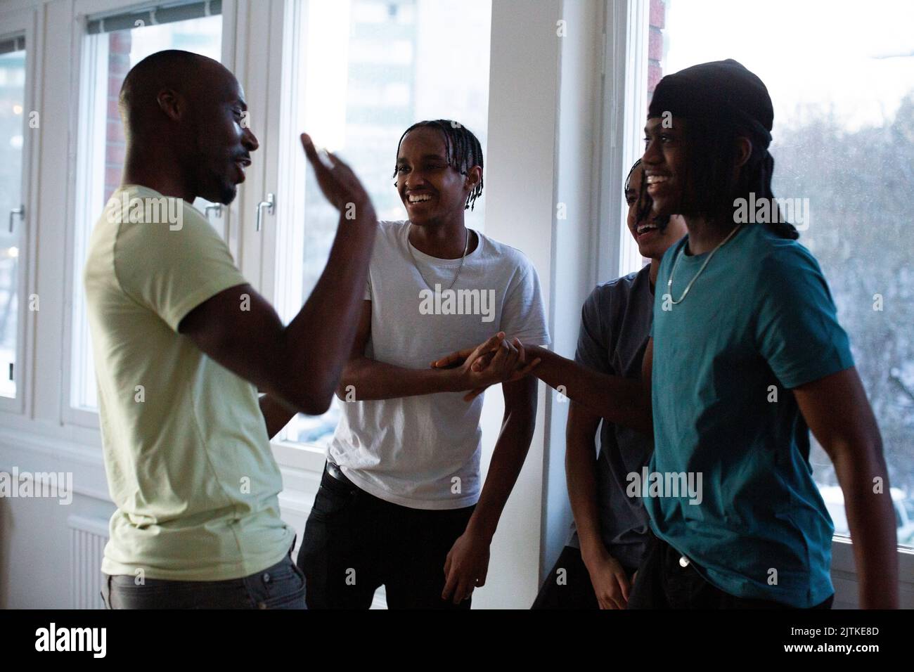 Happy students enjoying with coach in games room Stock Photo - Alamy