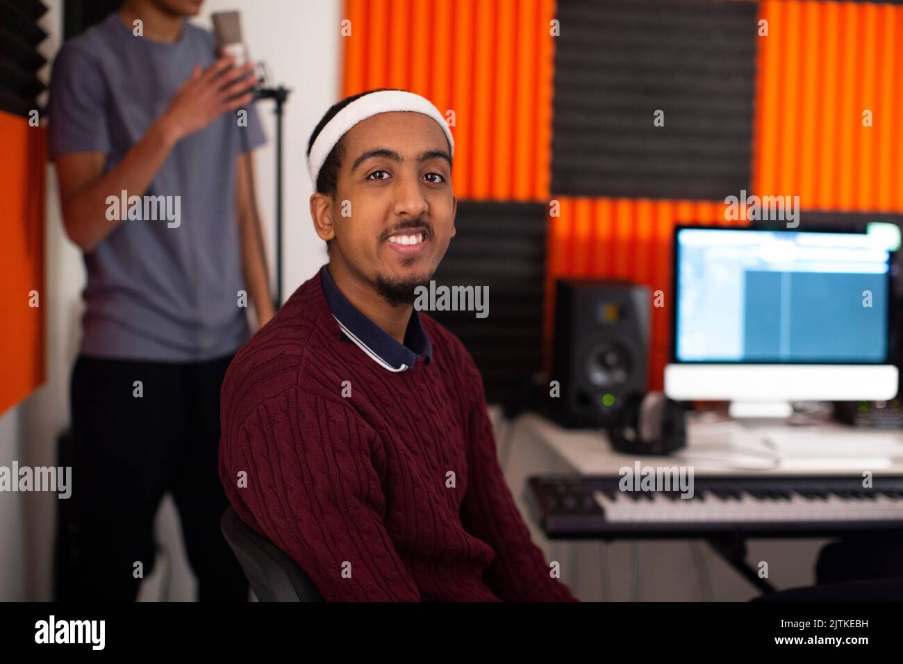 Portrait of smiling young man sitting in recording studio Stock Photo ...