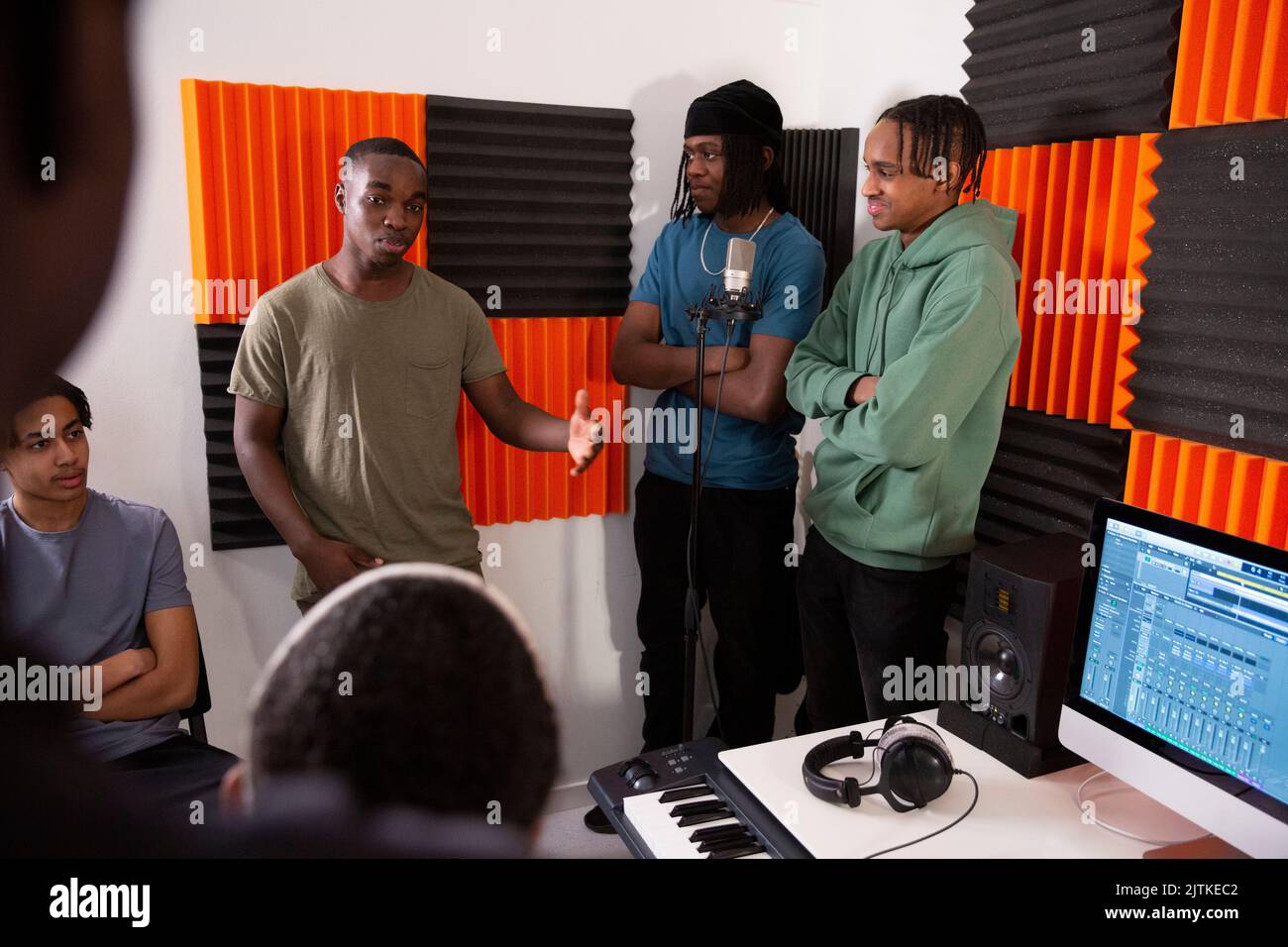 Sound engineer and rappers discussing in recording studio Stock Photo ...