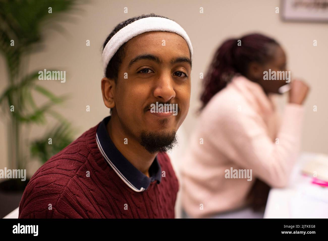 Portrait of smiling student sitting in classroom Stock Photo - Alamy