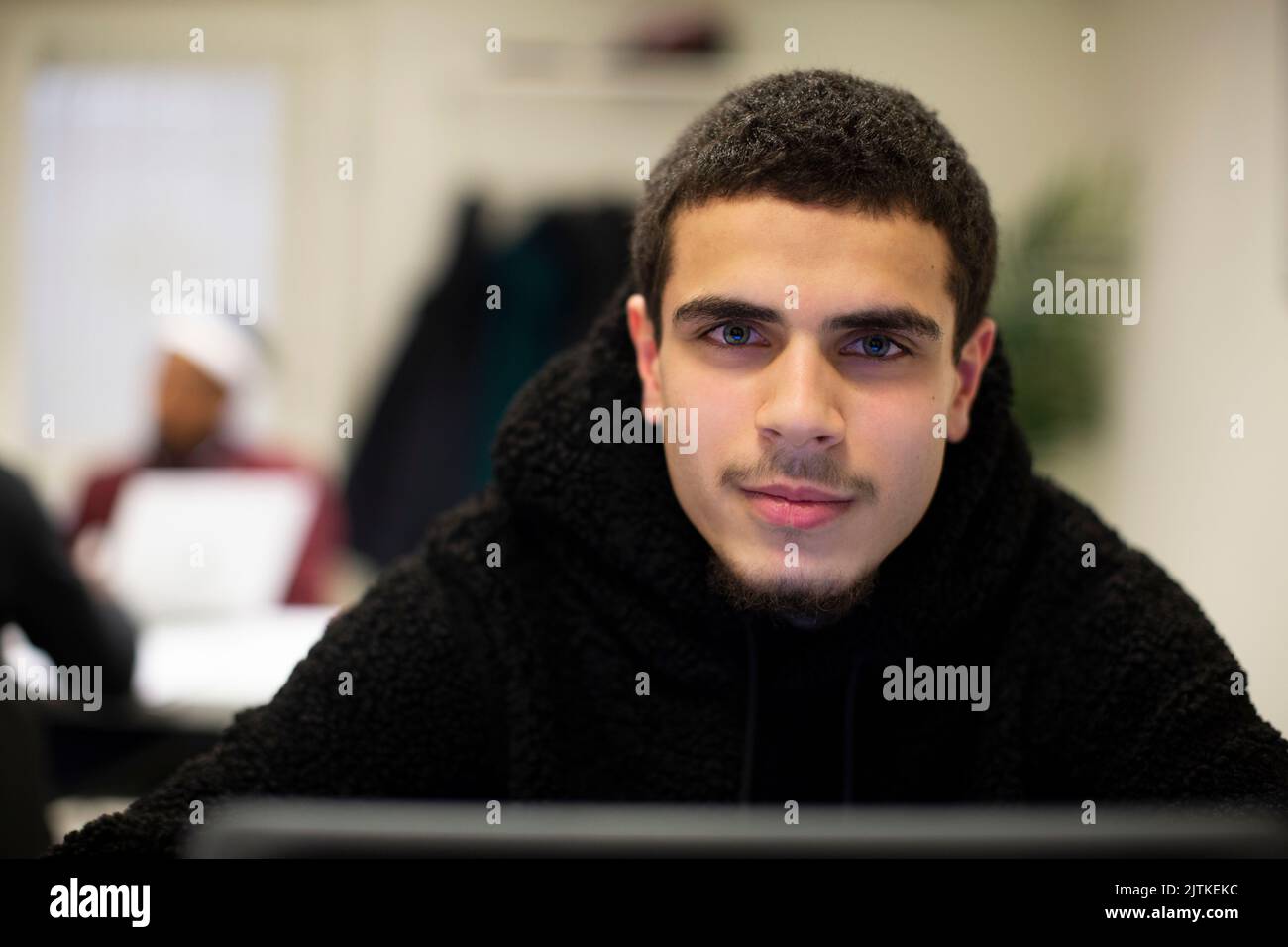 Portrait of student with short hair sitting in classroom Stock Photo ...