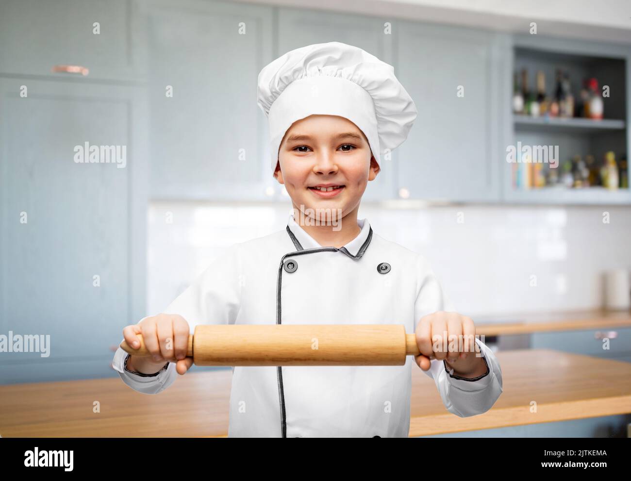 smiling boy in chef's toque with rolling pin Stock Photo - Alamy