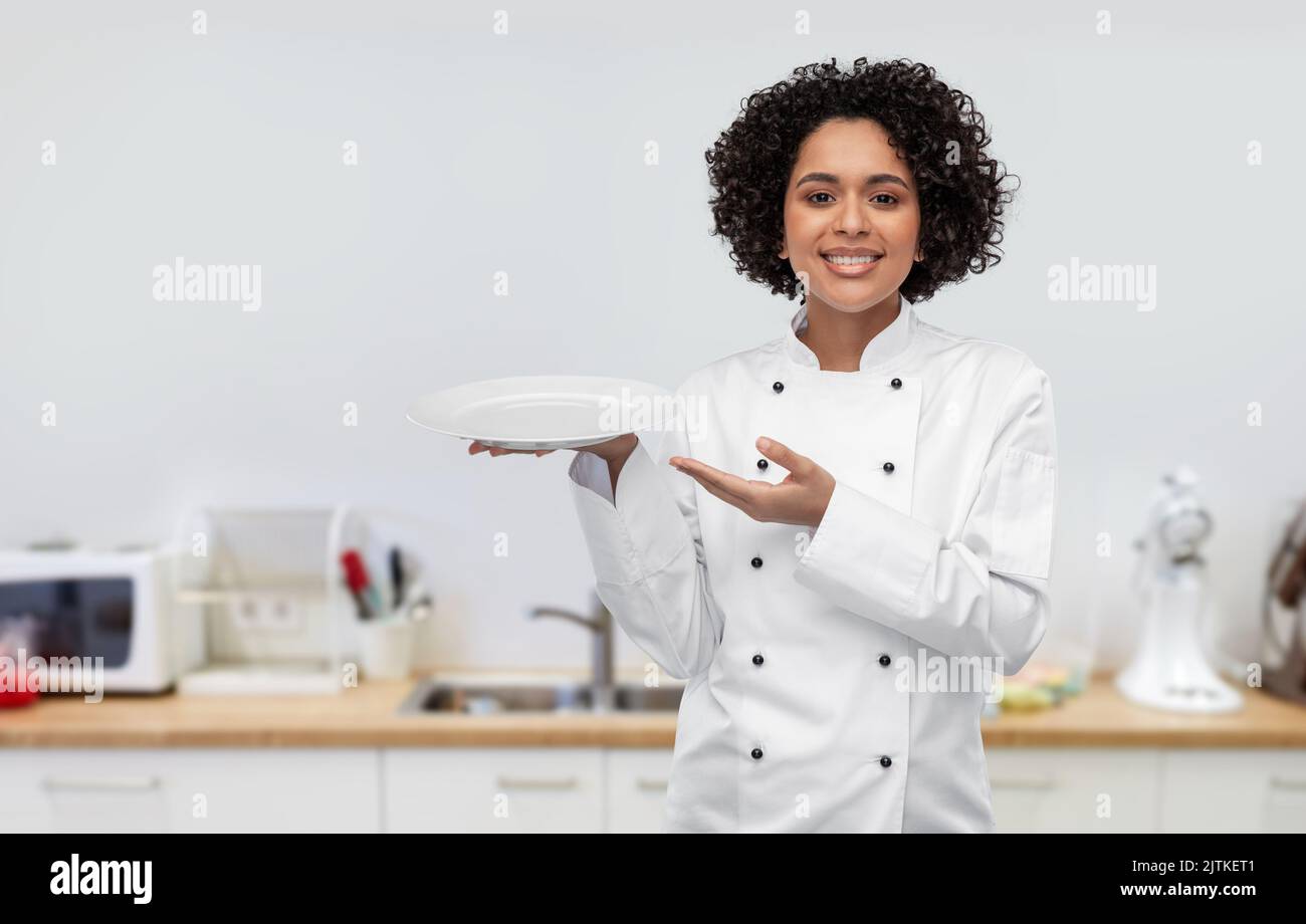 happy smiling female chef holding empty plate Stock Photo - Alamy