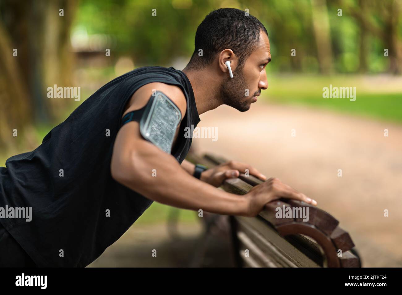 Motivated muscular arab guy exercising in the park, copy space Stock ...