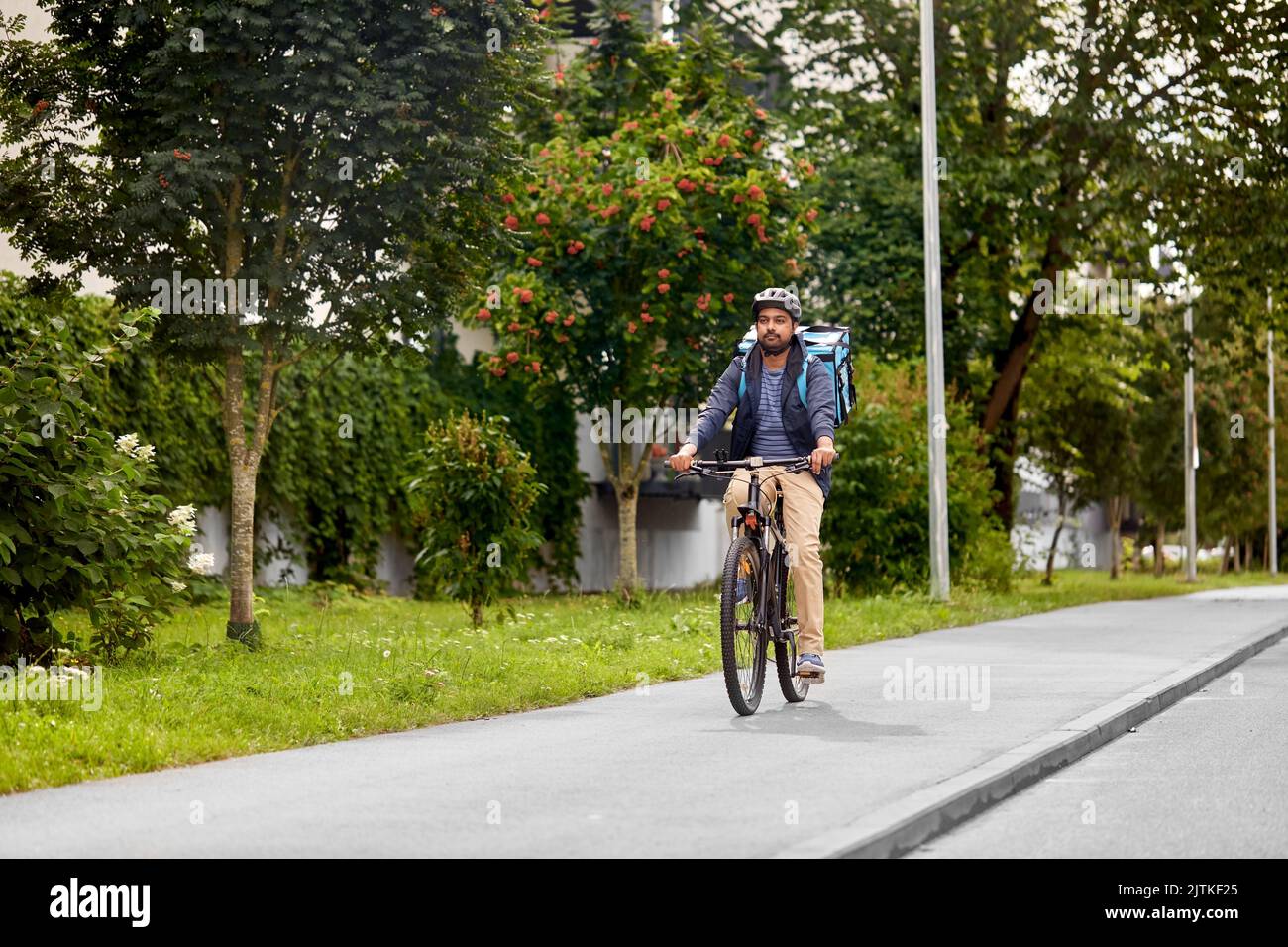 food delivery man with bag riding bicycle Stock Photo - Alamy