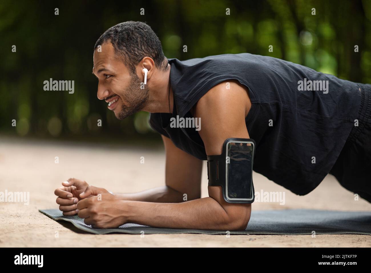 Side view of black guy having workout outdoors, planking Stock Photo ...