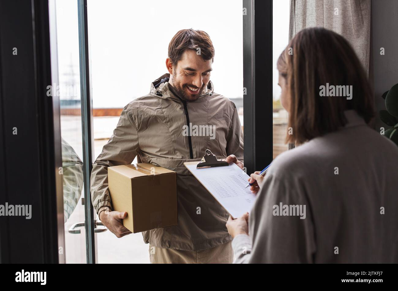 delivery man with parcel box and customer at home Stock Photo - Alamy