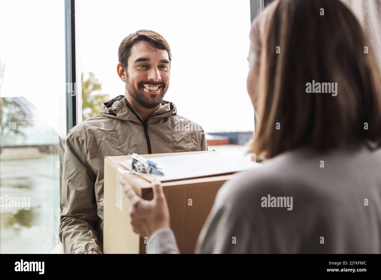 delivery man with parcel box and customer at home Stock Photo - Alamy