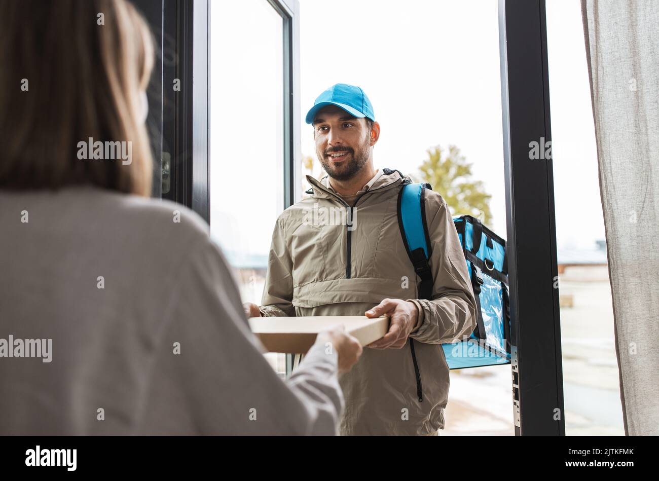 food delivery man giving order to female customer Stock Photo - Alamy