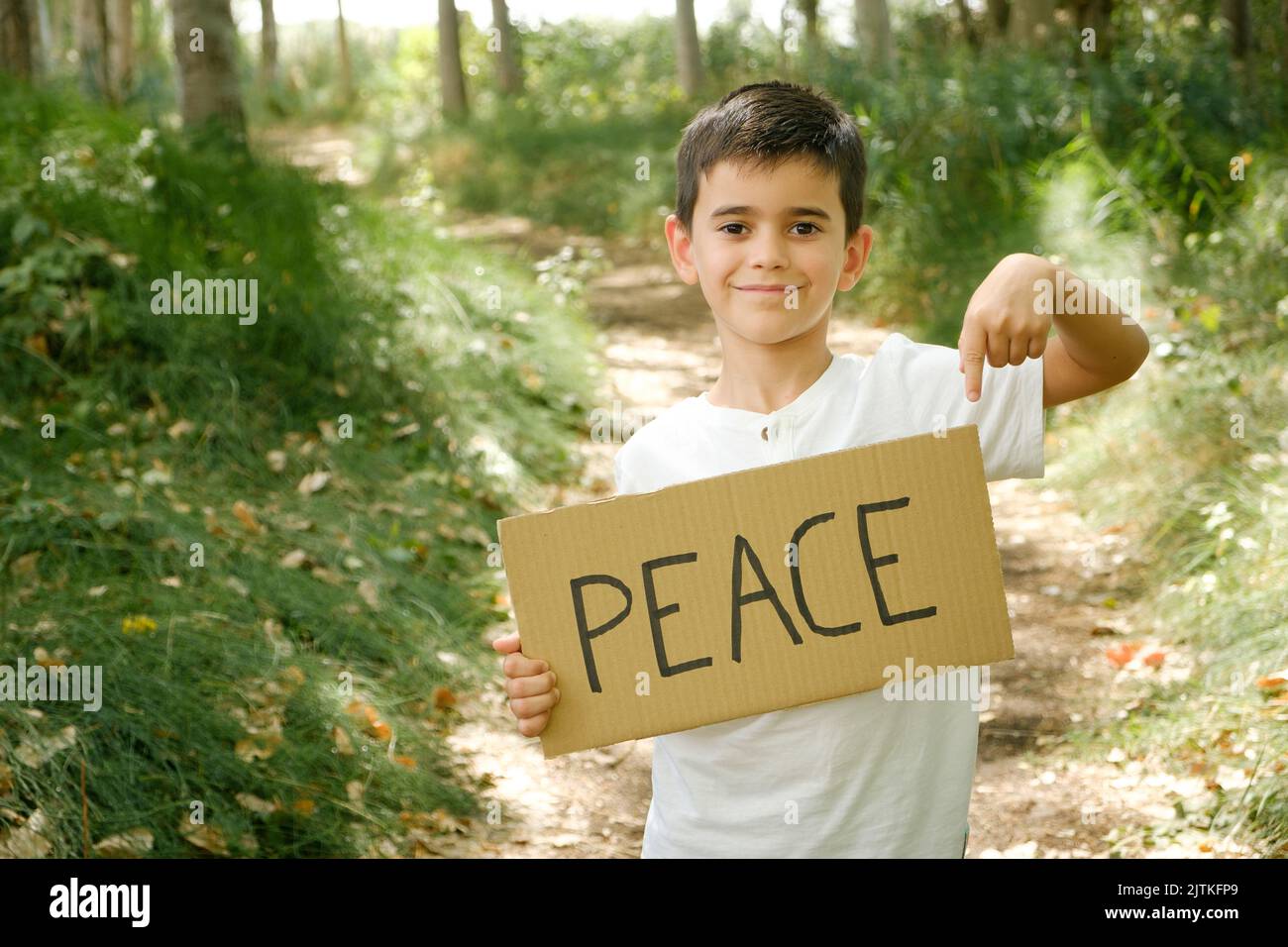 6-year-old boy holds a sign with the message "peace" in his hands Stock ...