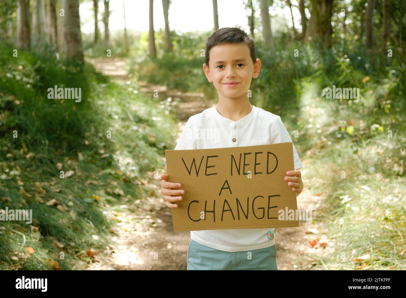 child holds a sign in his hands with the message "we need a change ...