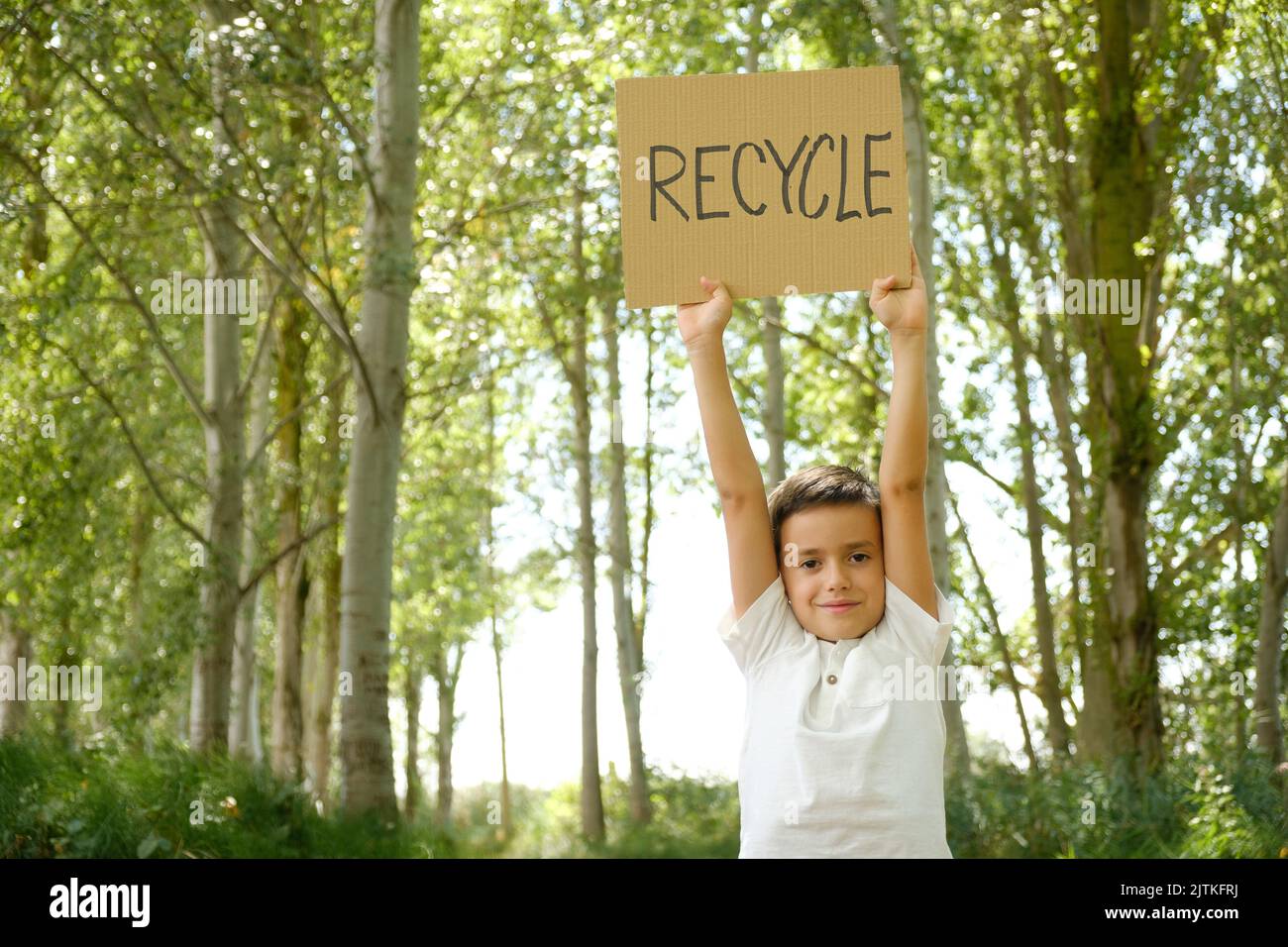 child in nature raises sign with the message "recycle Stock Photo - Alamy