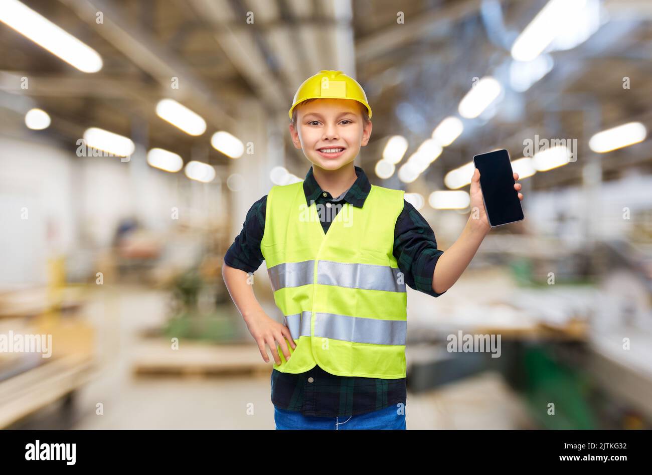 little boy in helmet and safety vest with phone Stock Photo - Alamy