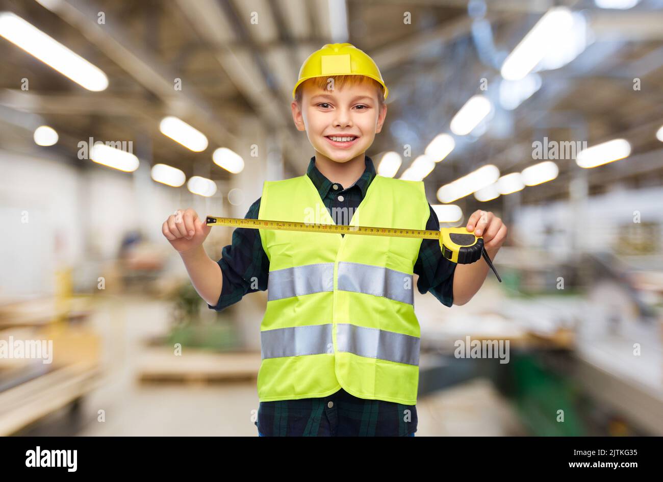 boy in construction helmet and vest with ruler Stock Photo - Alamy
