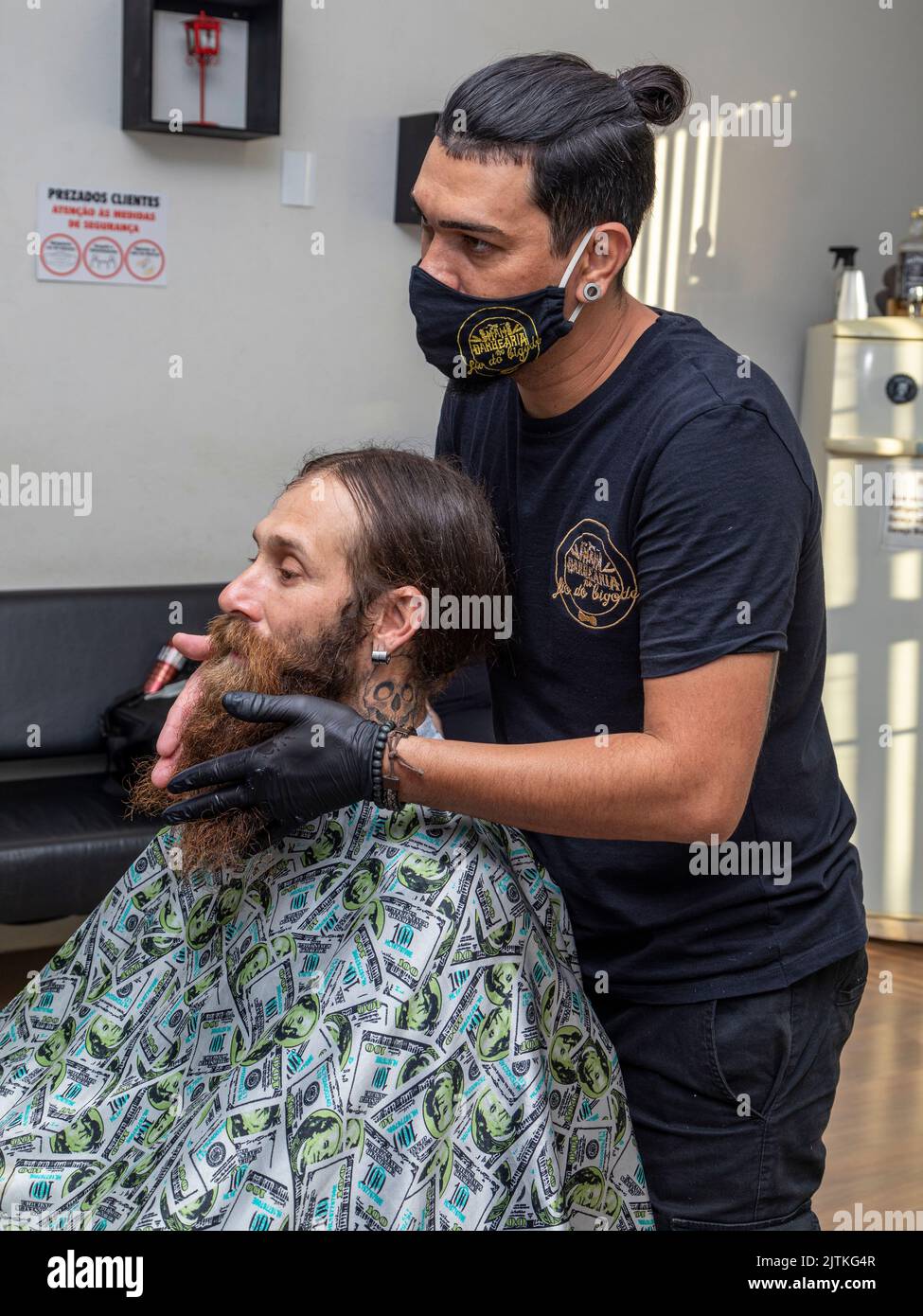 Barber applying cream on client's beard Stock Photo - Alamy