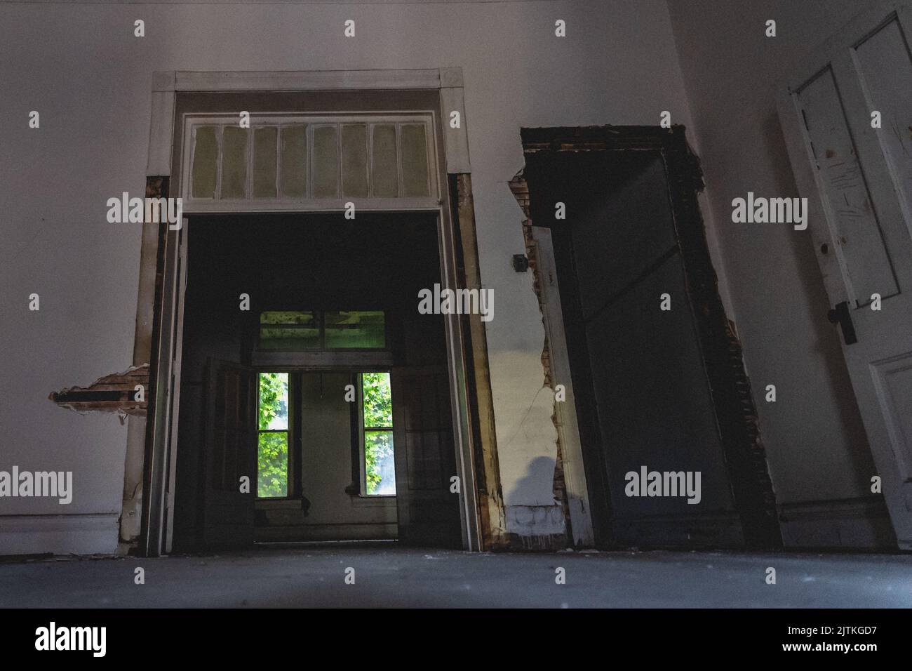 An old abandoned house with empty rooms with gray destroyed walls and ...