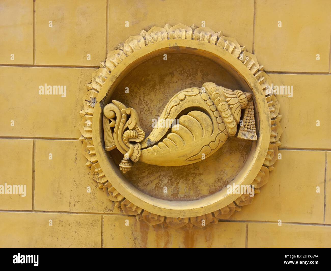 A stone sculpture of the Hindu Shankha hanging on the wall Stock Photo ...
