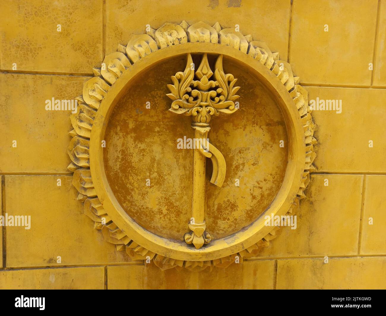 A stone sculpture of Trident of Madhu Hindu weapon hanging on the wall ...