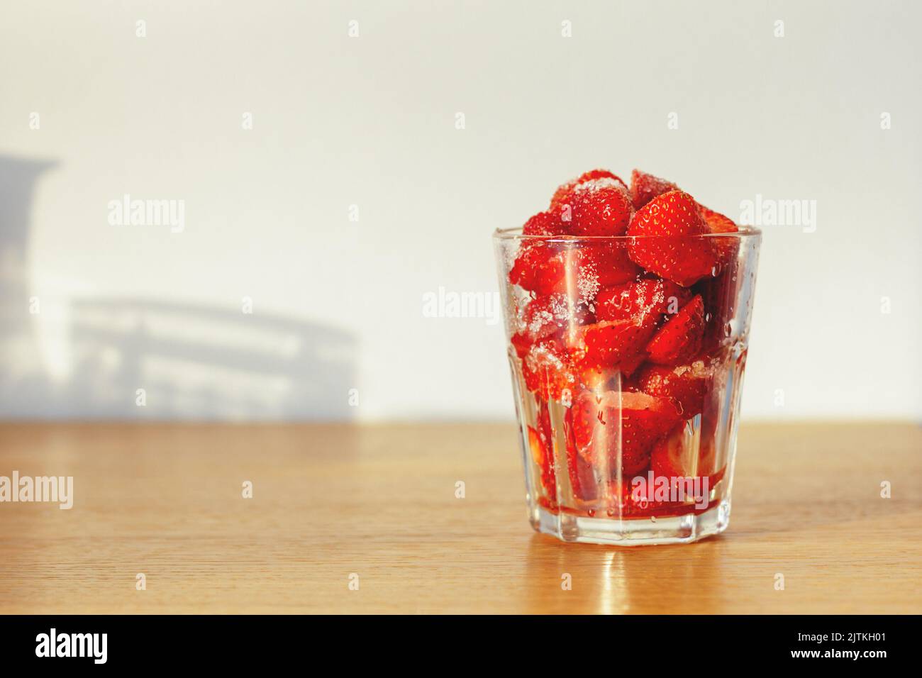 Ready to eat cut strawberries sprinkled with sugar in a glass. Summer ...