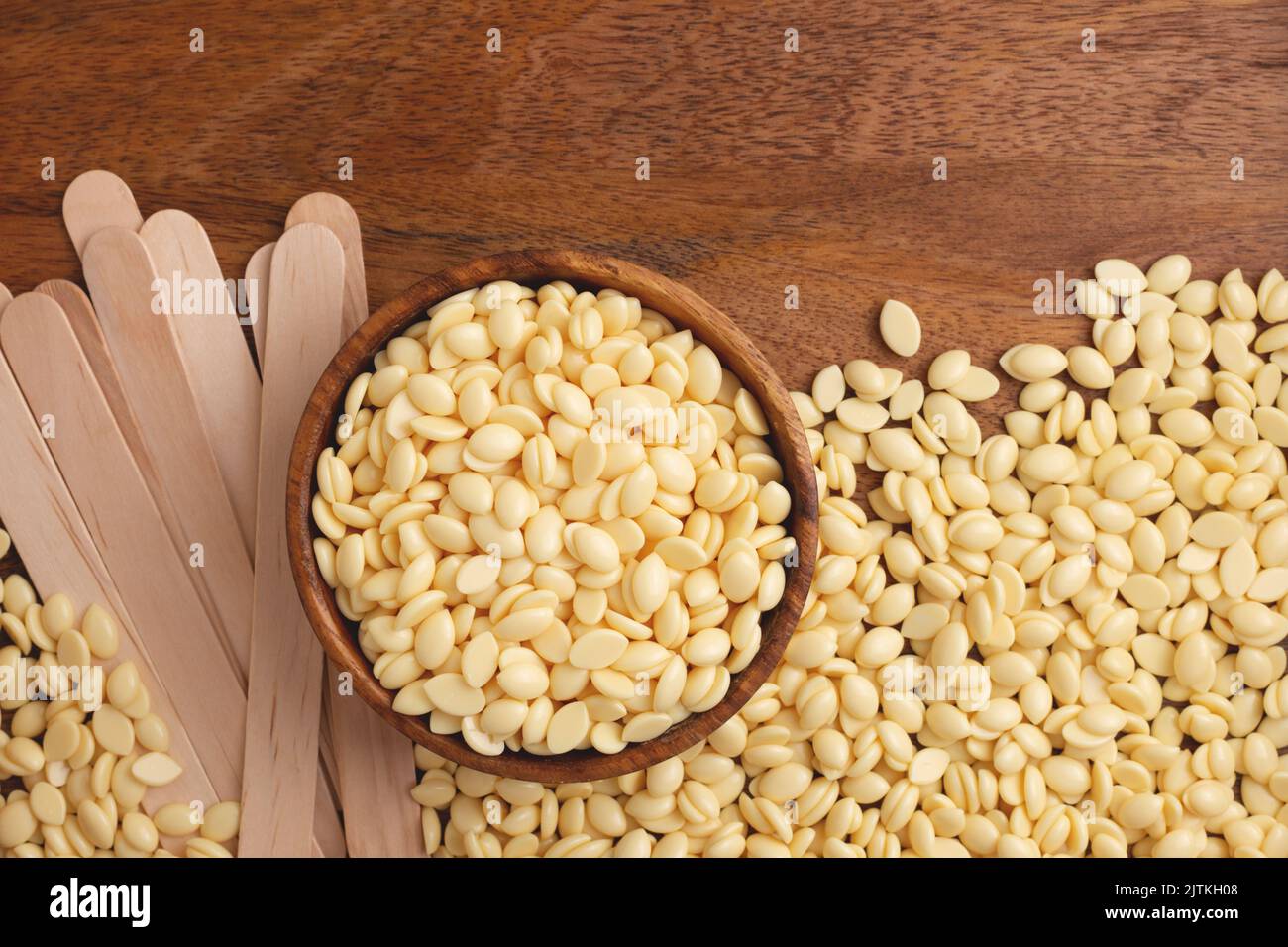 Natural hair removal wax beans in wooden bowl and wooden spatulas on ...