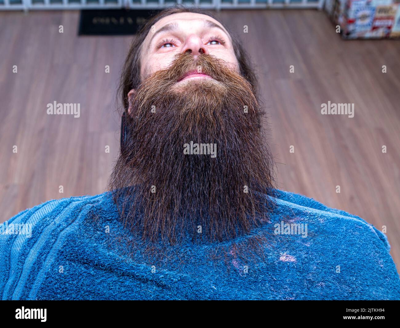 Red-haired man sitting in the barbershop chair showing off his ...