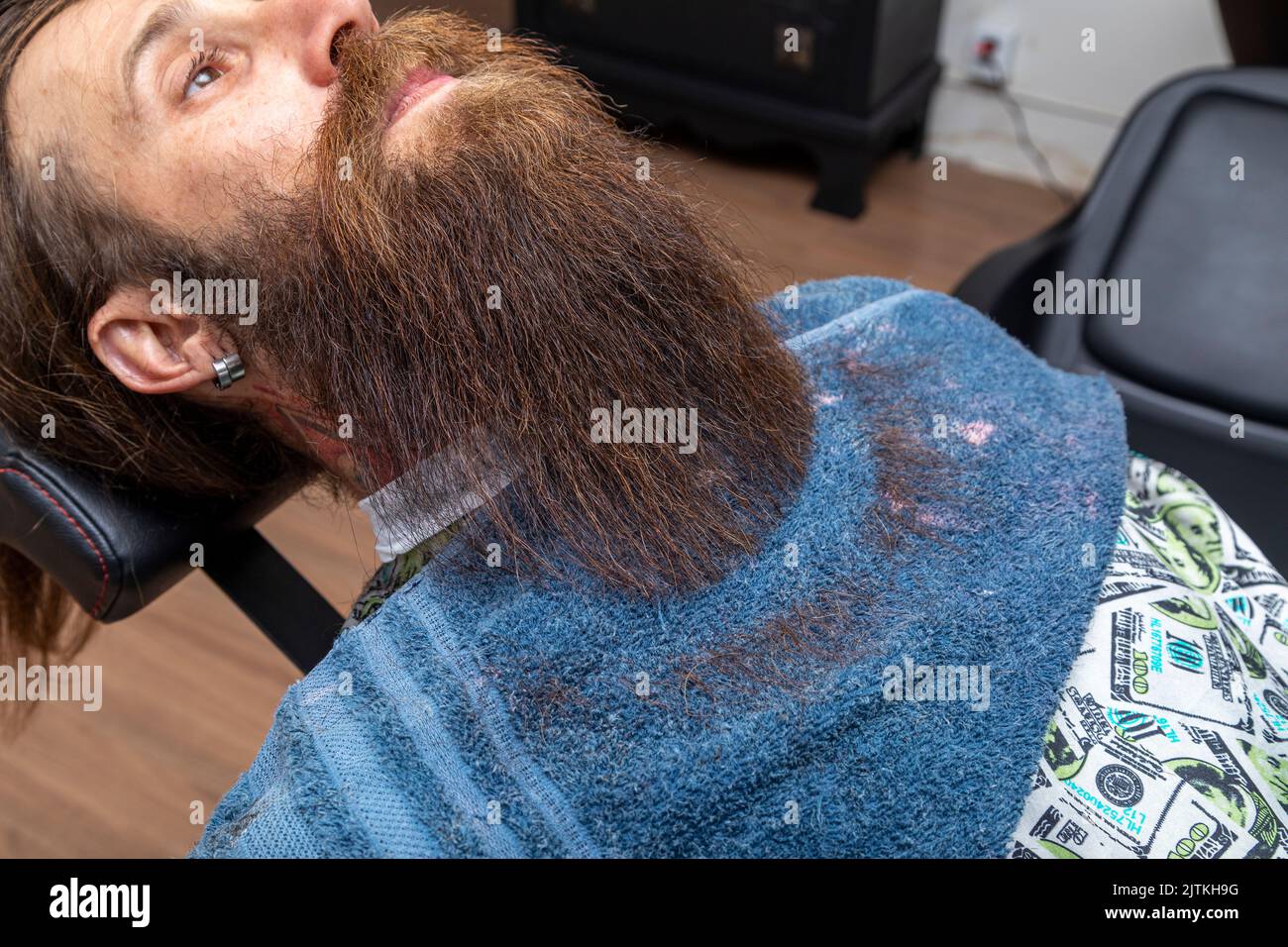 Red-haired man sitting in the barbershop chair showing off his ...